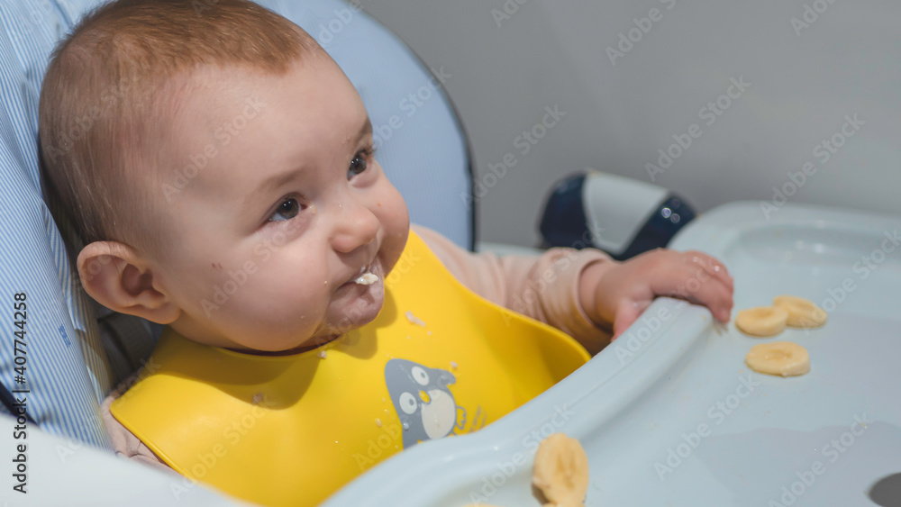 Cute baby girl eating porridge starting on solid food for the first ...