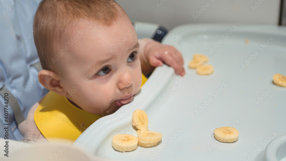 Cute baby girl eating porridge starting on solid food for the first ...