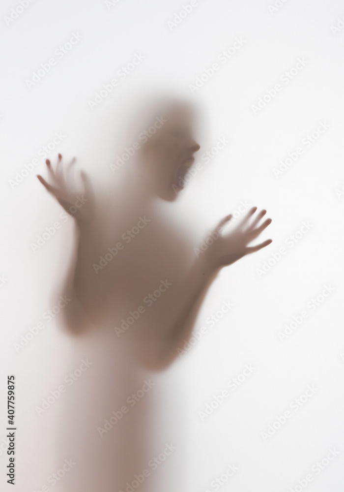 Scary diffuse human face and hands silhouette shouting behind a curtain ...