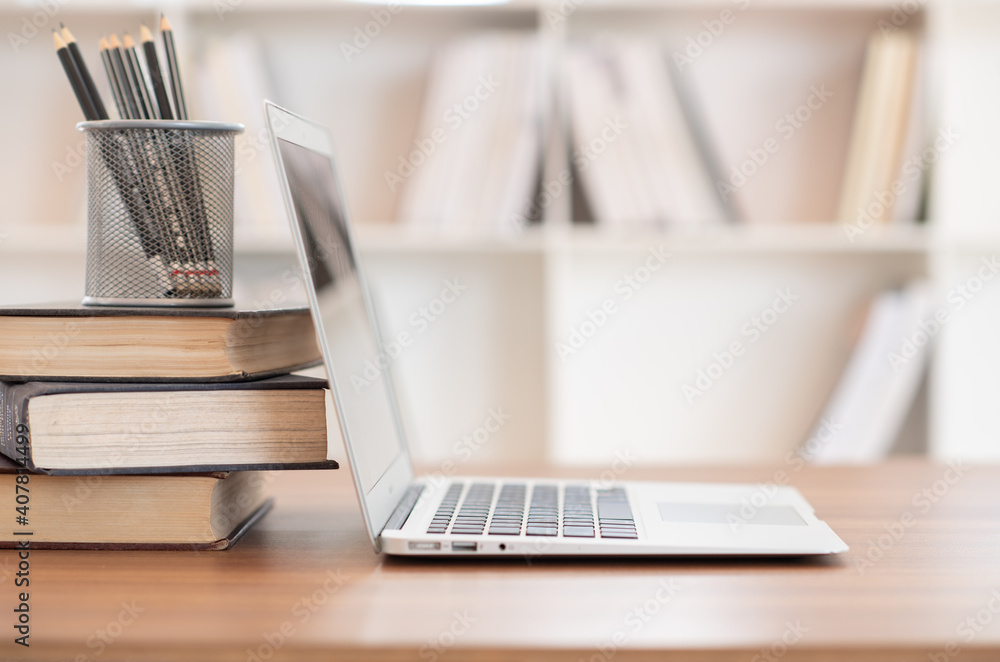 book stack and laptop on desk in library. education technology and e ...