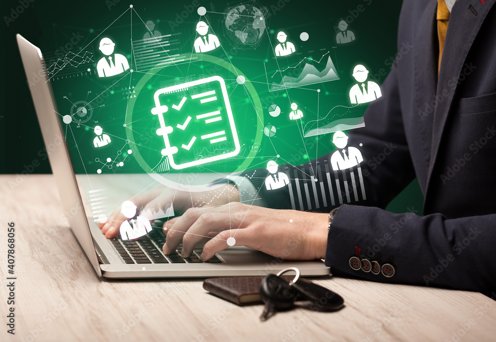 Business hand working on laptop with checklist icons coming out from ...