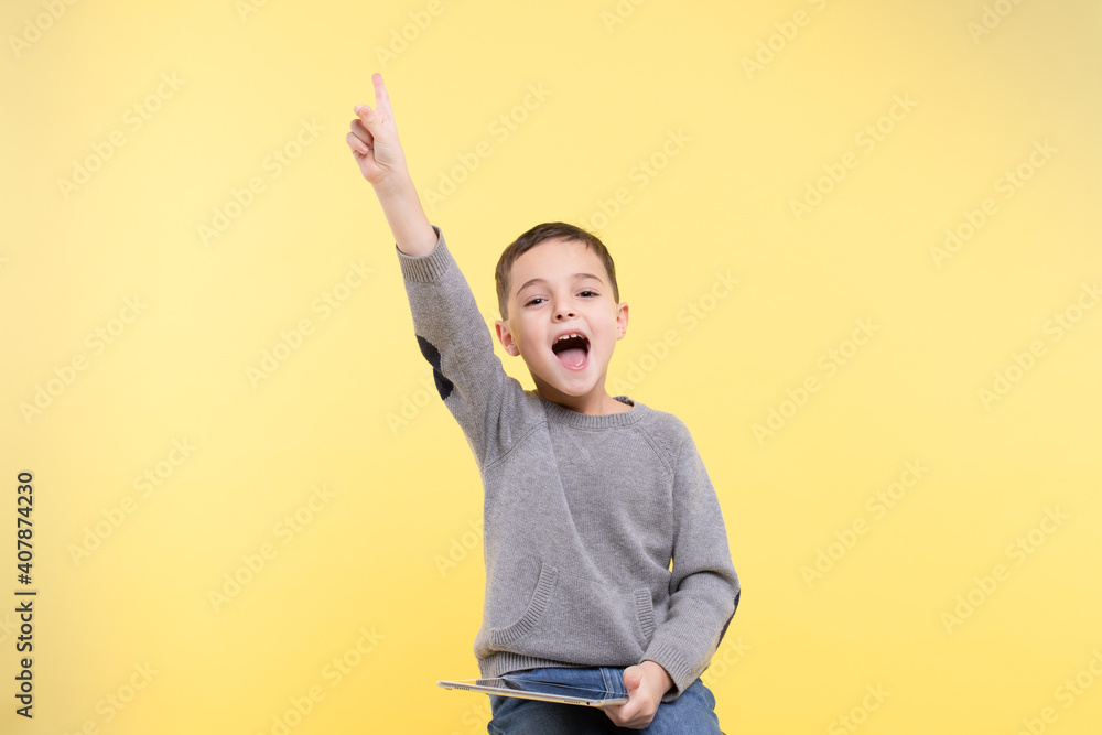Caucasian child with a tablet has a brilliant idea. Hand gesture ...