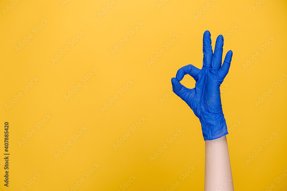 Closeup of male hand in medical protective gloves demonstrates ok sign ...
