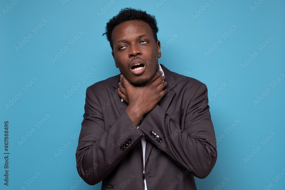 African man holding hands crossed on neck and chocking himself, feeling ...