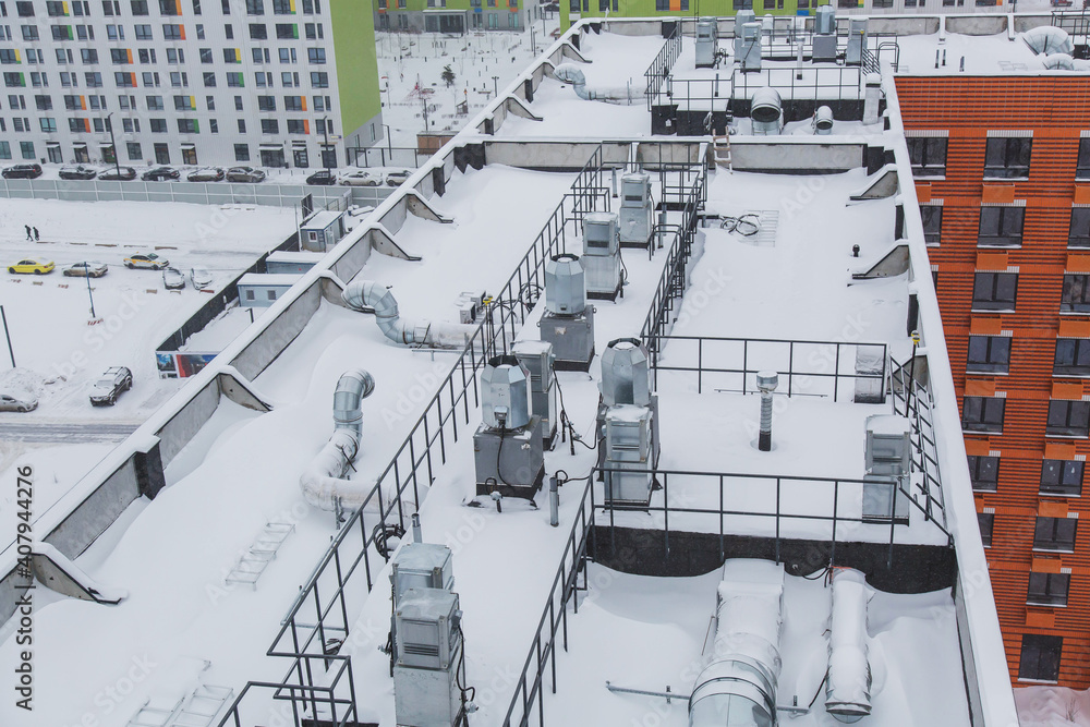 snow-covered roof with ventilation of a new high-rise apartment ...