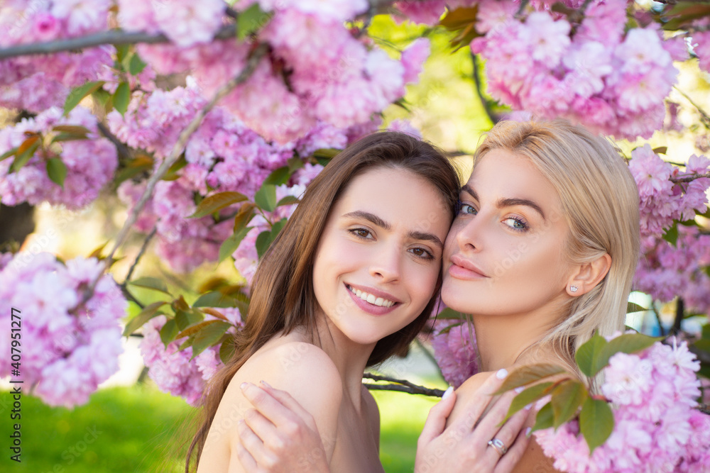 Smiling face of sensual girls. Beautiful young girls on blooming pink ...