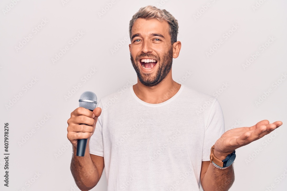 Handsome blond singer man with beard singing song using microphone over ...