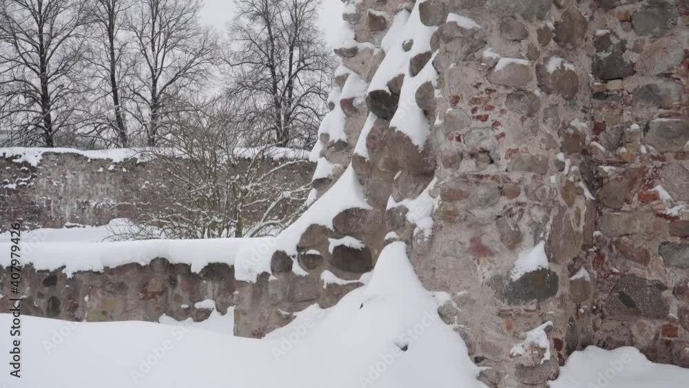 Covered with snow an ancient stone wall fragment in a close-up view in ...