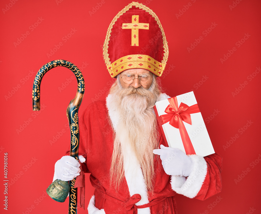 Old senior man with grey hair and long beard wearing saint nicholas ...