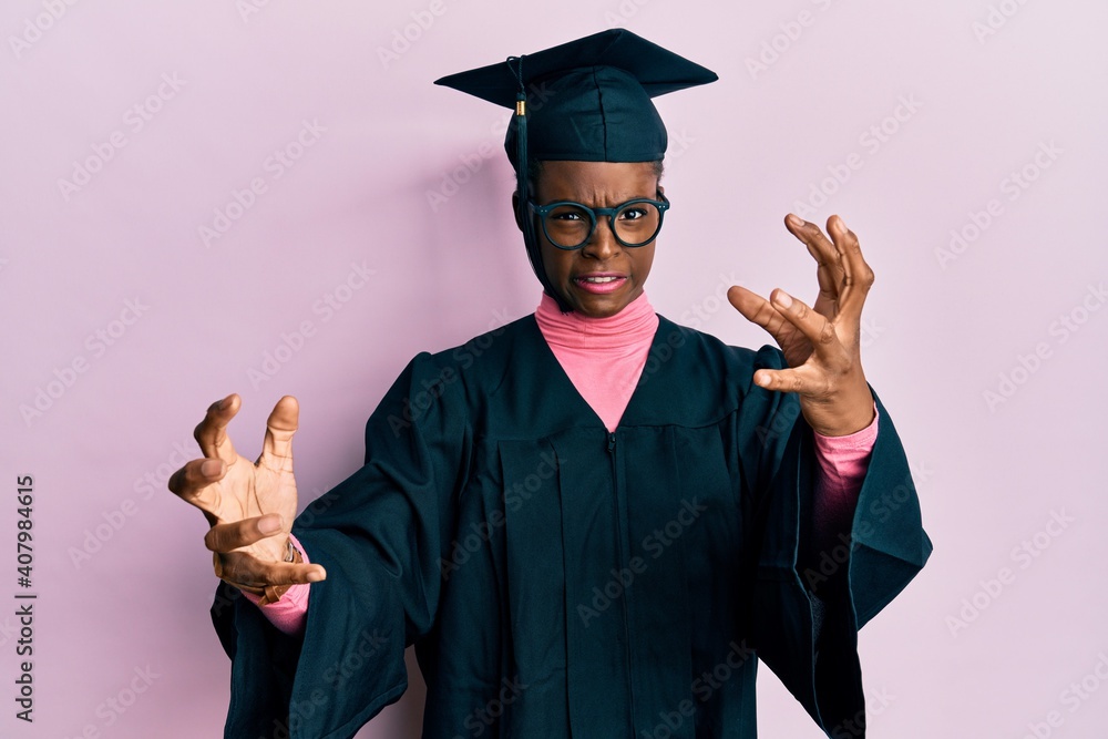 Young african american girl wearing graduation cap and ceremony robe ...