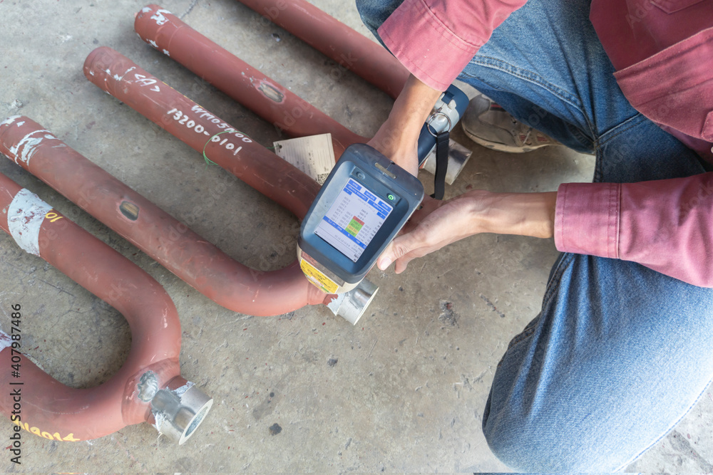 Worker inspect metal components of steel pipes with The Portable XRF ...