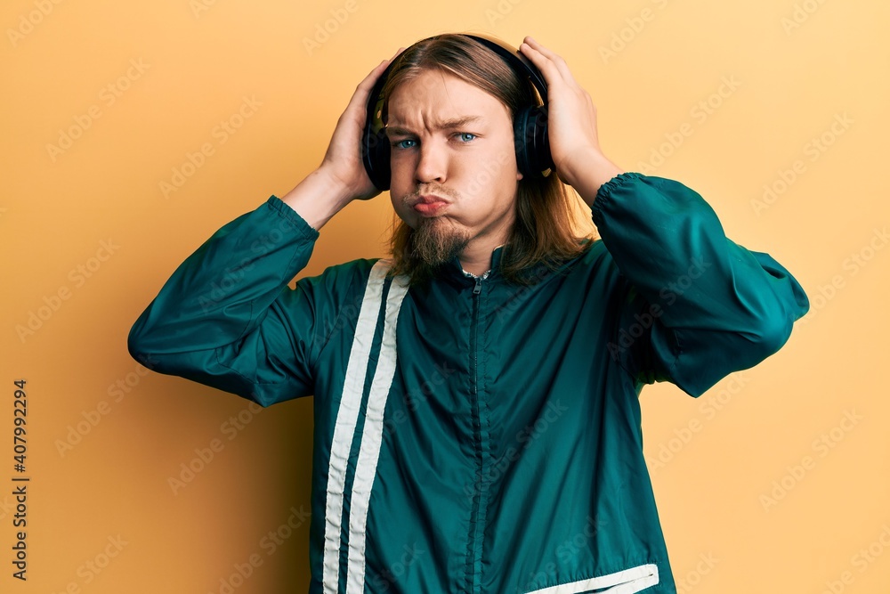 Handsome caucasian man with long hair wearing gym clothes and using ...