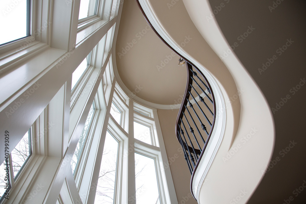 Beautiful staircase in a circular shape with giant windows from floor ...