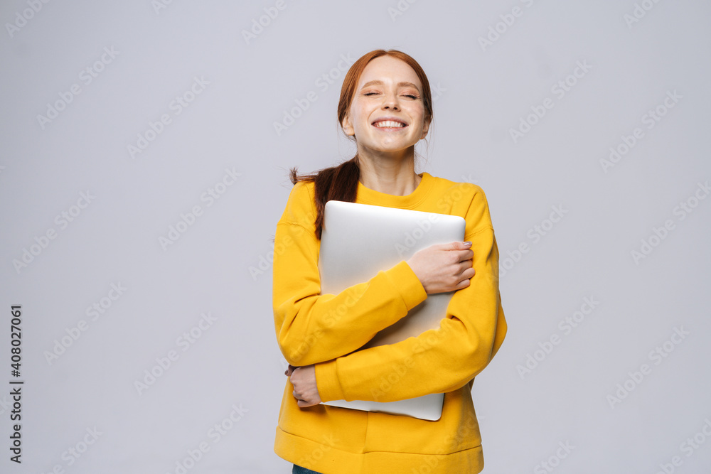 Smiling young woman student holding laptop computer and looking at ...