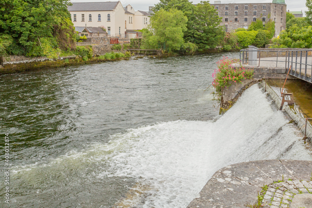 Water entering the Corrib river through a small dam forming a waterfall ...