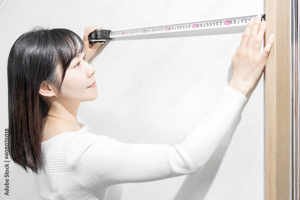 Standing woman measuring with a tape measure Stock Photo | Adobe Stock