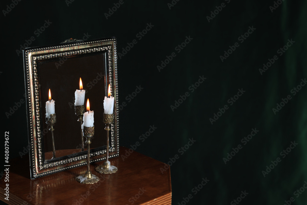 Mystic still life with mirror, reflection and two burning candles ...