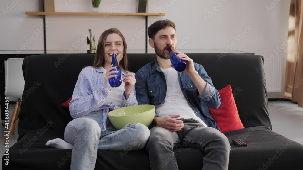 Joyful young caucasian boyfriend and girlfriend sitting on the sofa ...