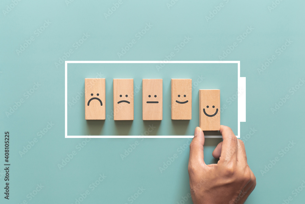 Hand putting wood smile face emoticon with outline battery. Happy of ...