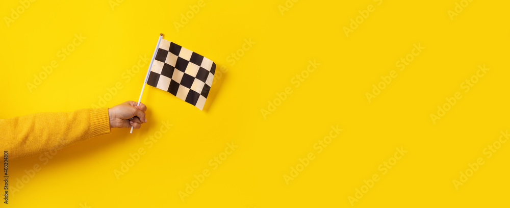 checkered flag in hand over yellow background, panoramic image Stock ...