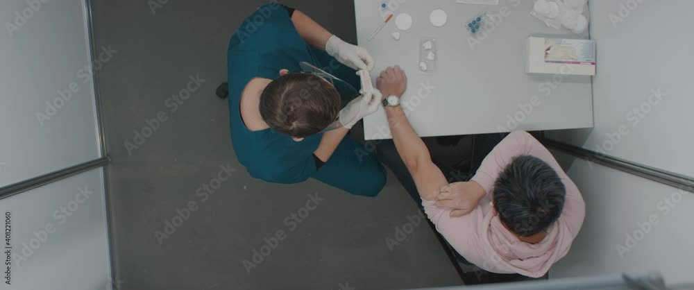 OVERHEAD HIGH ANGLE OVERHEAD Doctor sticks a plaster after ...
