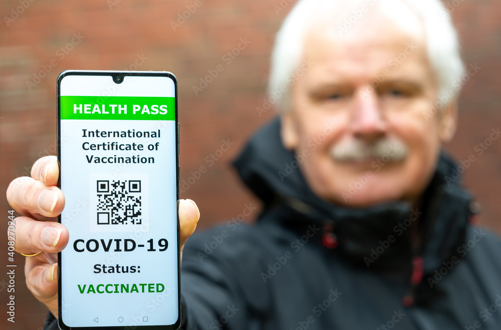 Senior man showing a health pass on a mobile phone, which indicates a ...