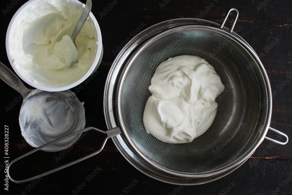 Straining Plain Yogurt in a Mesh Sieve: Yogurt in a mesh sieve placed ...