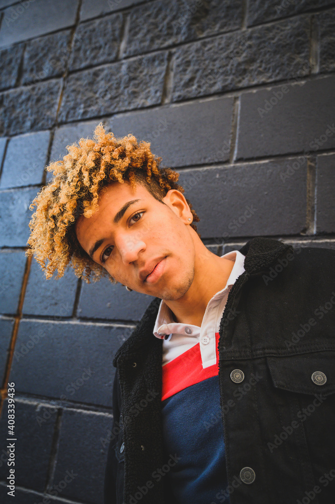 Hombre joven latino, moreno de ojos marrones y con pelo rizado en un ...