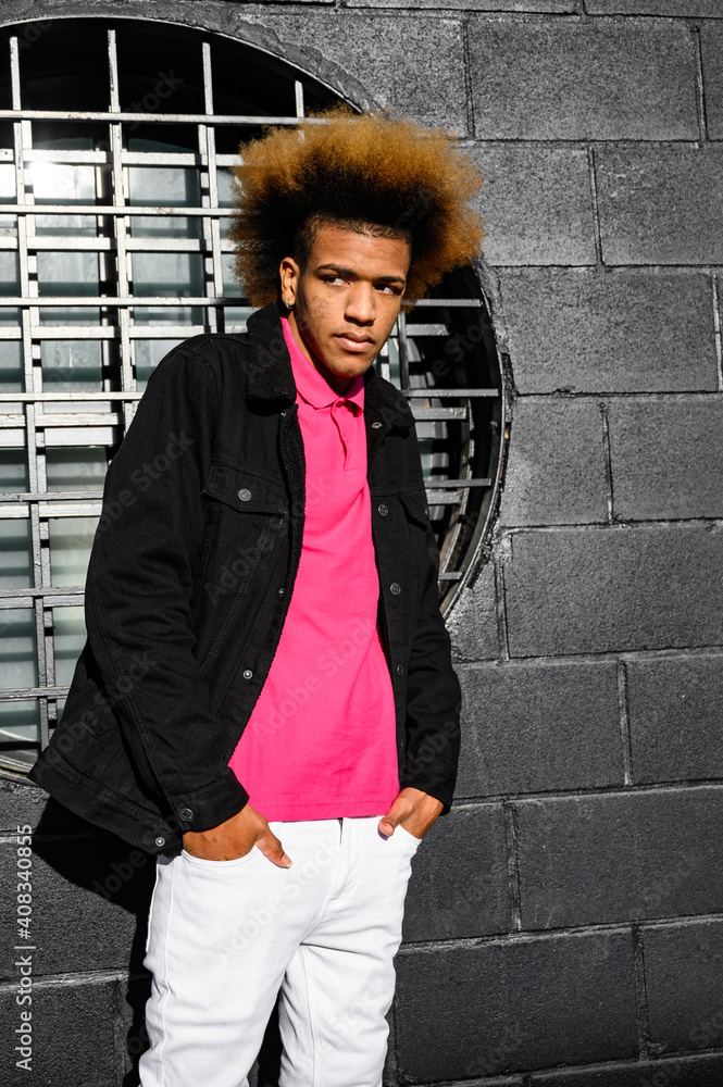 Hombre joven latino, moreno con pelo rizado a lo afro sentado en un ...