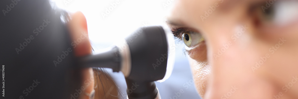 Doctors holding otoscope near patients ear in clinic close-up ...