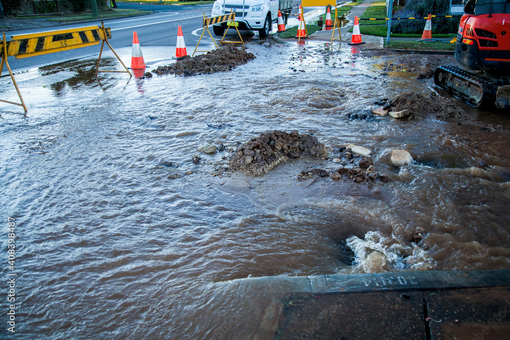 Water and mud over a town road from a broken water main Stock Photo ...