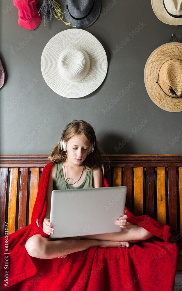 tween girl using a laptop, with headphones Stock Photo | Adobe Stock