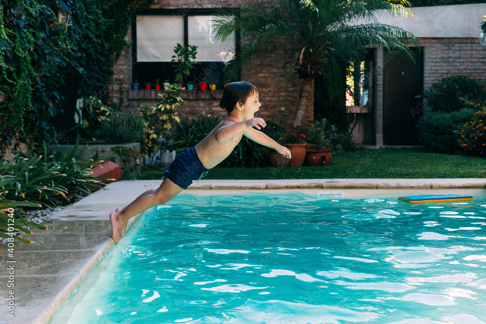 Little boy jumping in a pool. Child get fun in the swimming pool of his ...