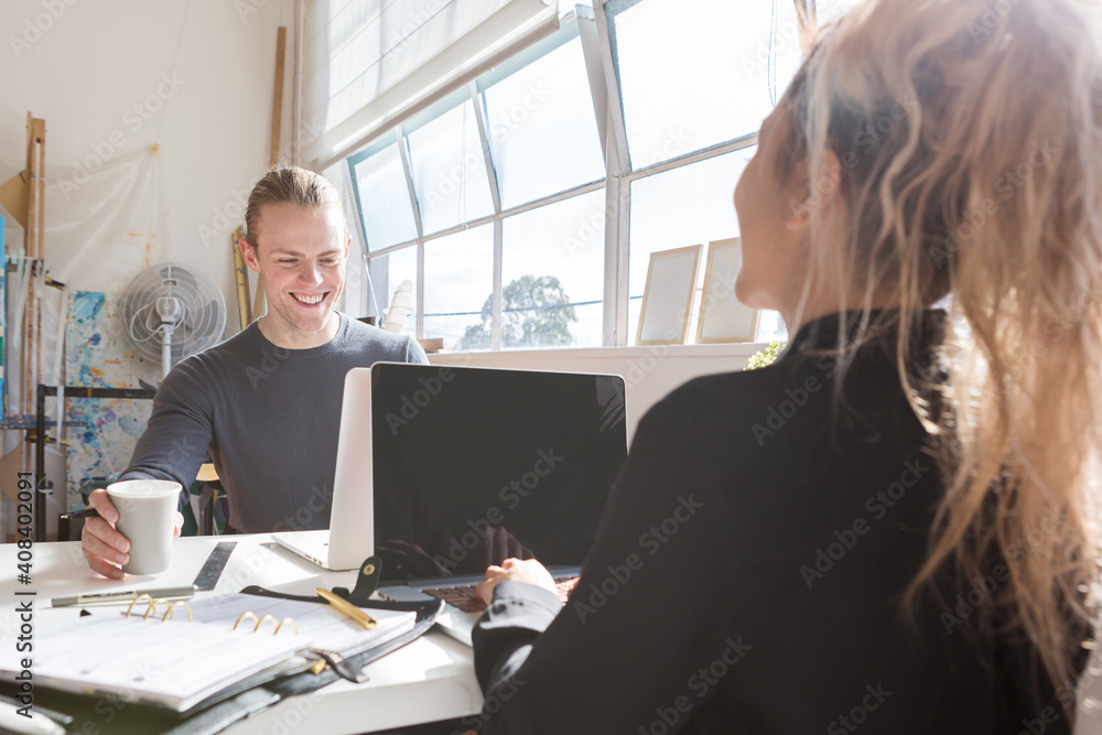 Coworkers at a shared desk in a creative studio workplace Stock Photo ...