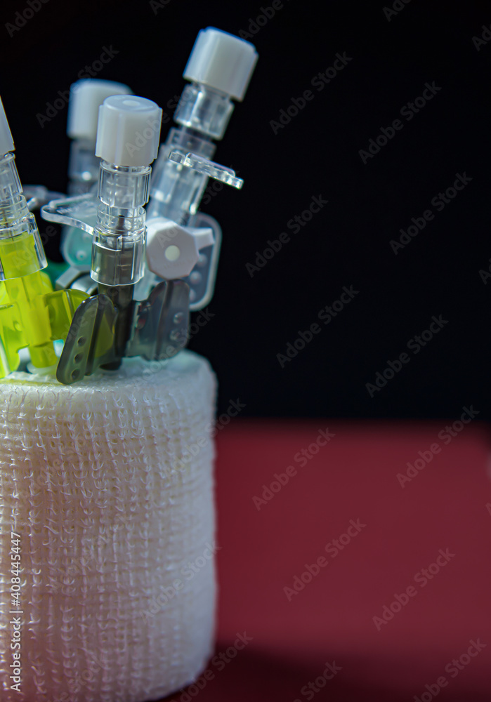 intravenous catheters of different sizes close-up on a black and red ...