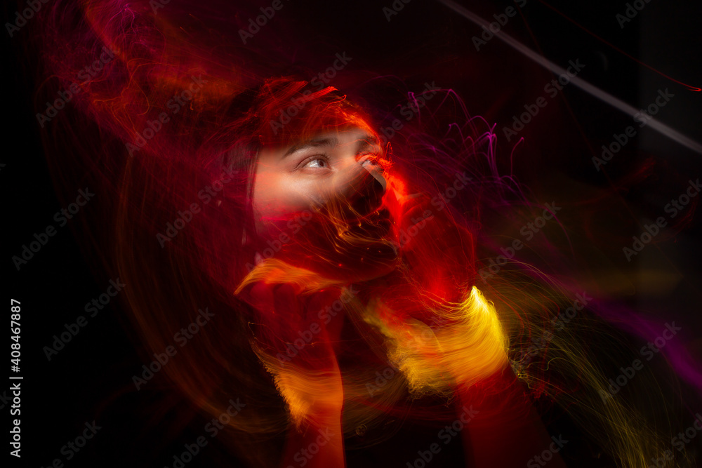 Portrait of young woman amid light painting , Over Black Background ...