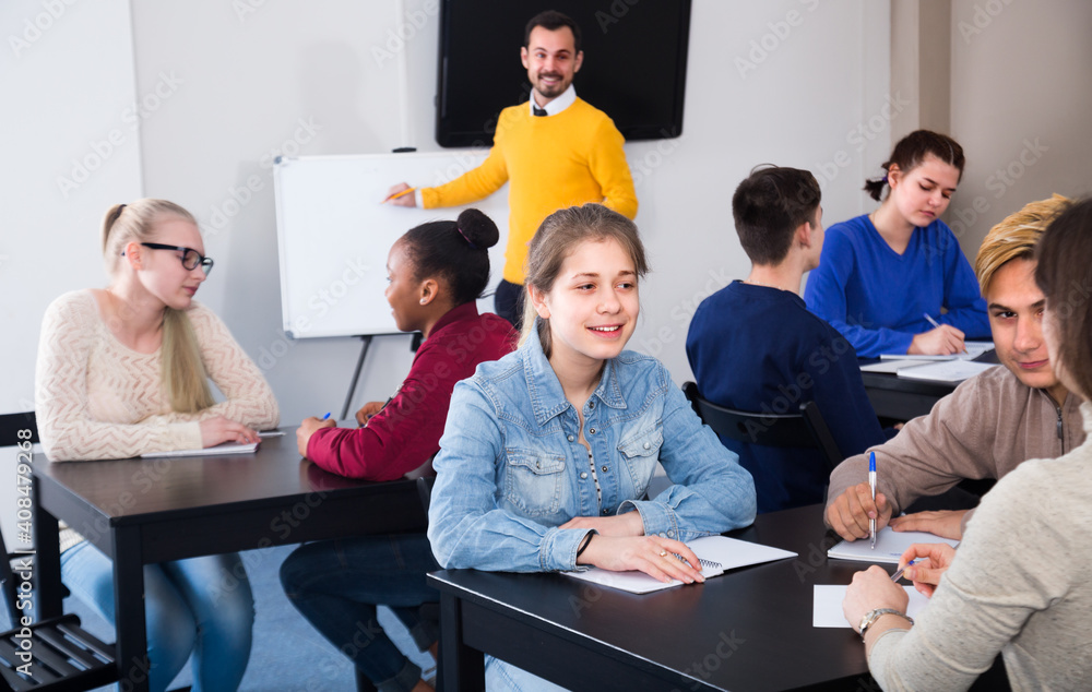 Girls and boys 15-18 years old are working in large groups in school ...