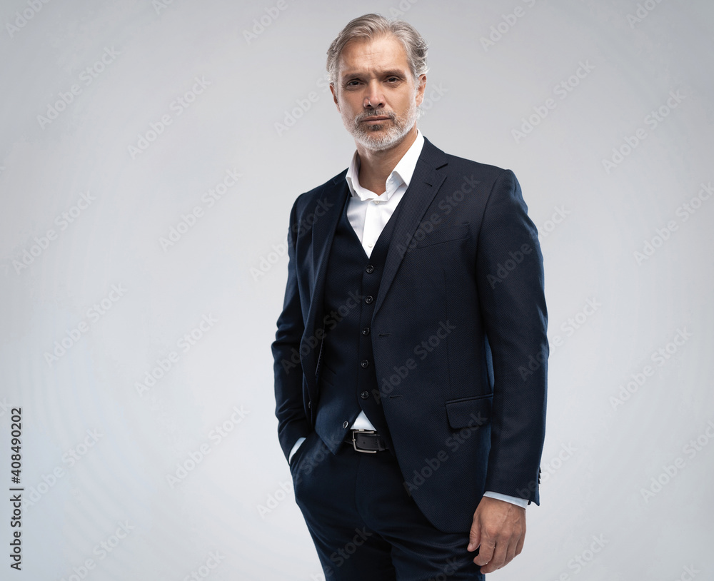 Handsome middle-aged man in suit posing against grey background Stock ...