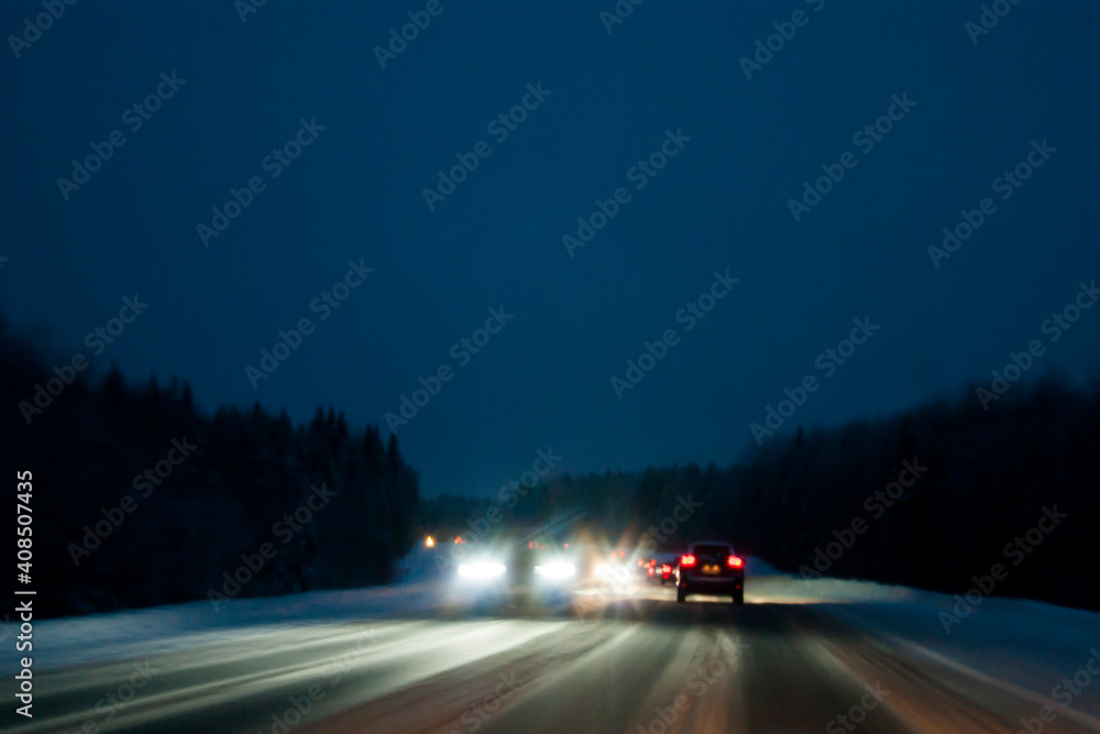 Night highway in winter. Light headlights in the dark, the movement of ...