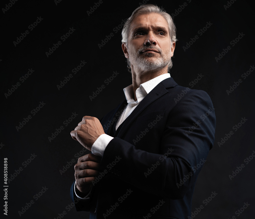 Handsome middle-aged man in suit posing against black background Stock ...