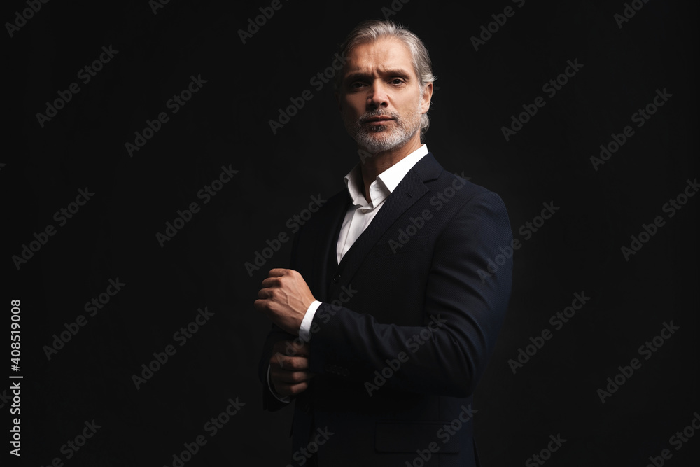 Handsome middle-aged man in suit posing against black background Stock ...