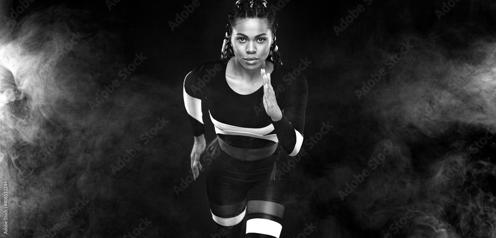 Strong athletic woman sprinter, running on black background wearing in ...