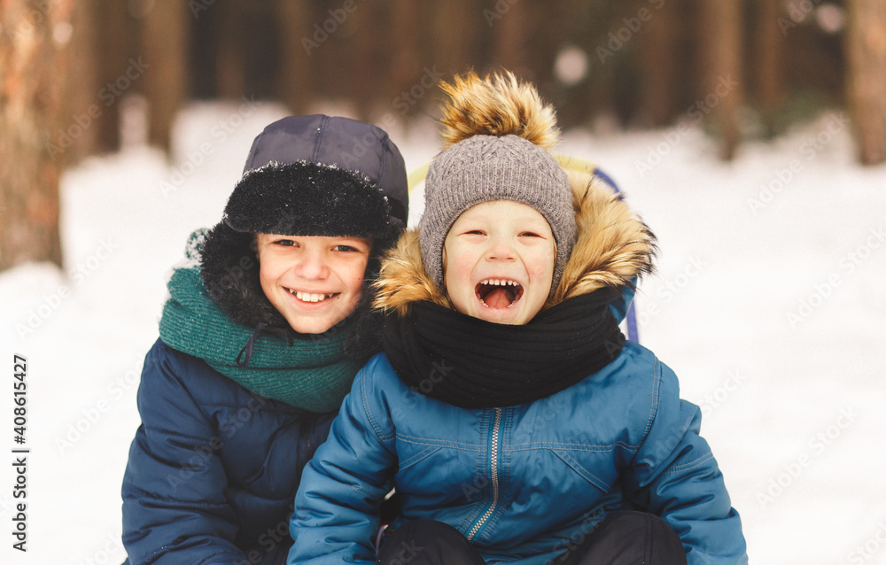 Two boys in the winter in nature cuddle. Two brothers have fun outdoors ...