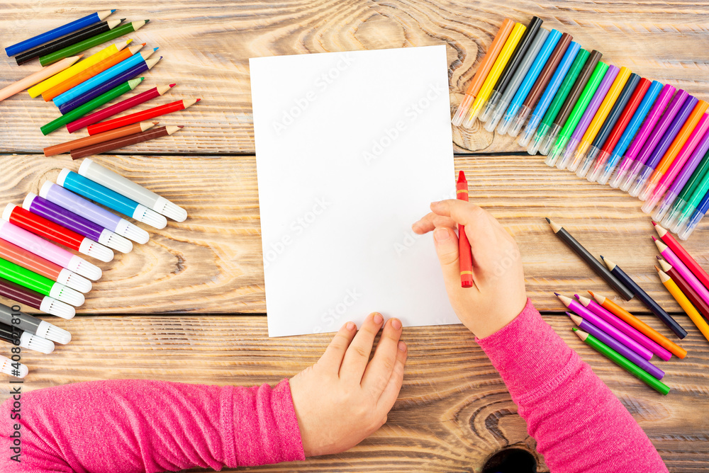 Little girl prepares to paint on a blank sheet of paper. Drawing is ...