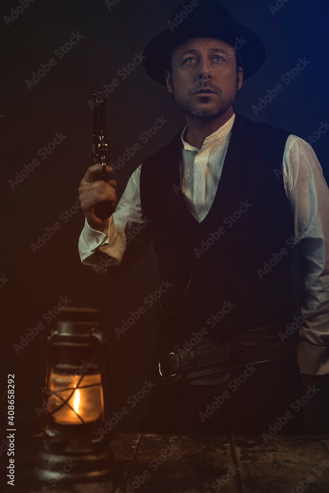 Retro victorian style cowboy with revolver behind wooden table with ...