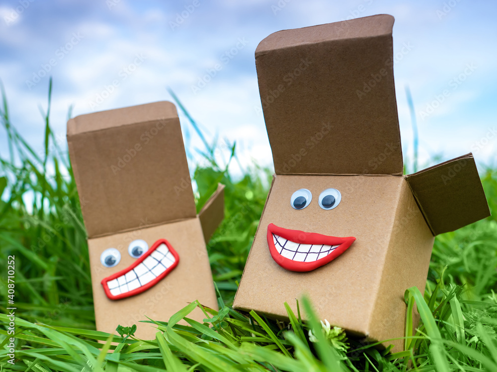 Foto de Opened cardboard boxes on green grass. Small boxes in grass ...