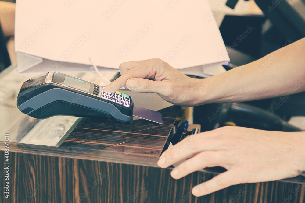 Shop cashier operating payment process with pos terminal and credit ...