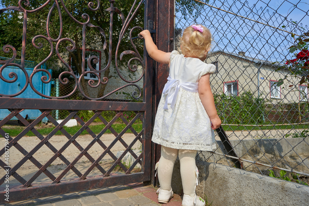 little girl comes out of the gate,in the summer the little girl in a ...
