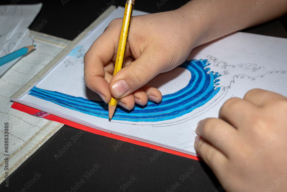 Hand with pen of a child drawing a picture. Stock Photo | Adobe Stock