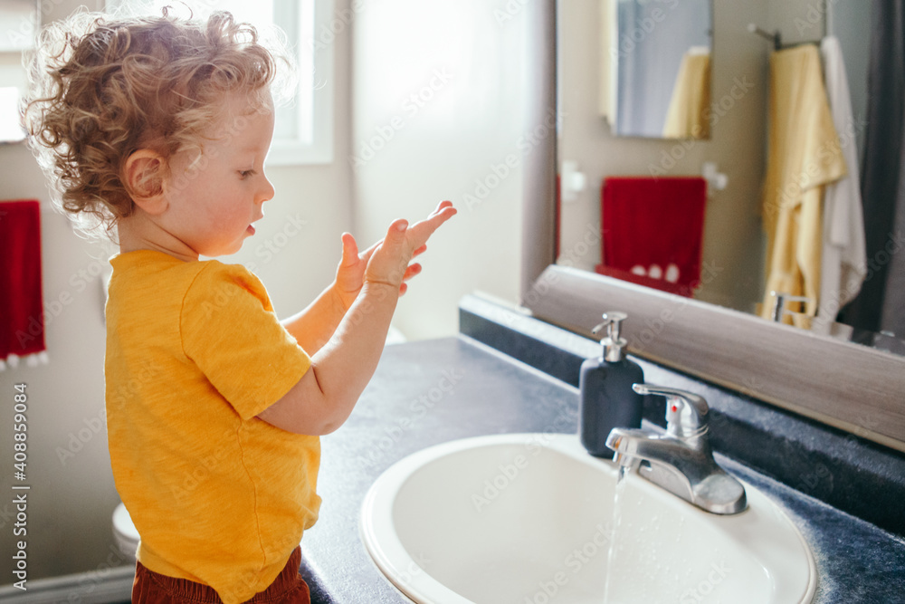Little Caucasian boy toddler washing hands in bathroom at home. Health ...